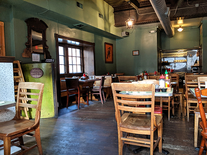 The dining room feels like your coolest friend's living room &ndash; sage green walls, wooden tables, and windows that frame the day like perfect Polaroids.