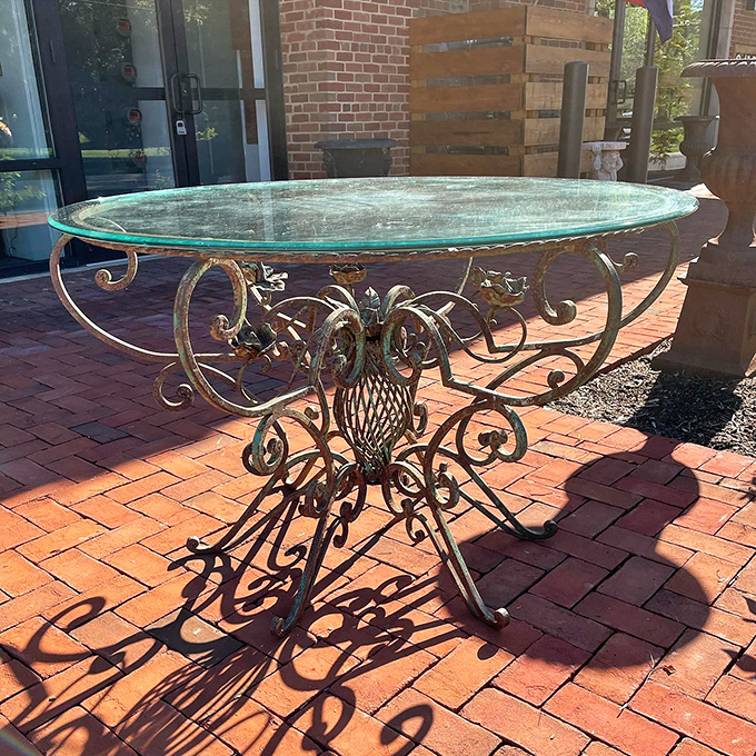Wrought iron meets glass in this garden table that casts shadows as artistic as the piece itself. Outdoor elegance defined!