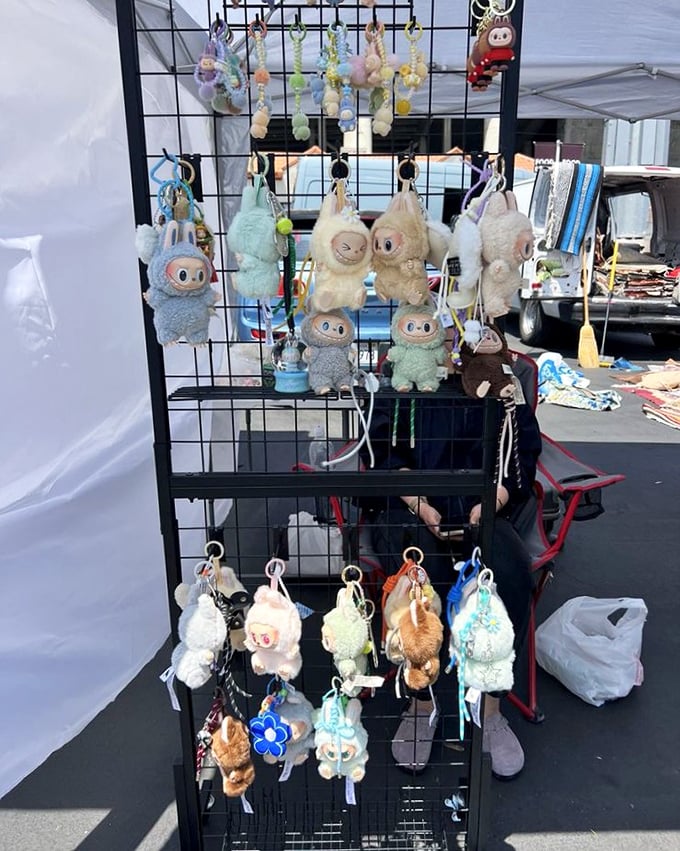 Quirky plush keychains dangle like cheerful sentinels, guarding the entrance to a booth filled with whimsical collectibles and nostalgic trinkets.