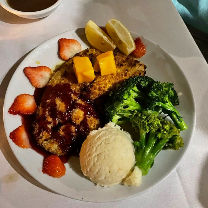 Mahi-mahi gets the royal treatment with a golden crust, fresh strawberries, and a scoop of ice cream that somehow makes perfect sense in this tropical setting.