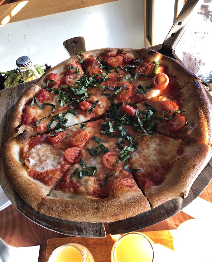 Fresh basil and cherry tomatoes dancing atop a perfectly charred crust – pizza that tastes like summer, regardless of season.