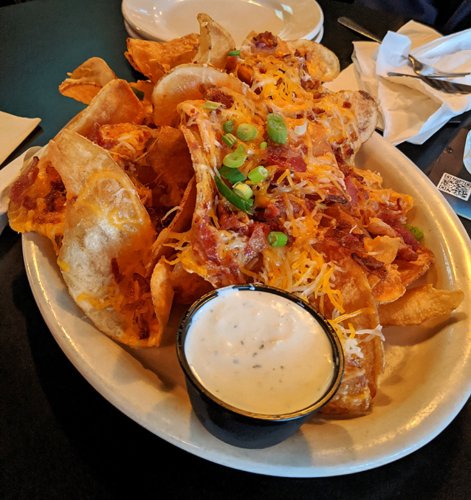 Pub chips transformed into an indulgent masterpiece with melted cheese, bacon bits, and a side of ranch that feels like necessary excess.