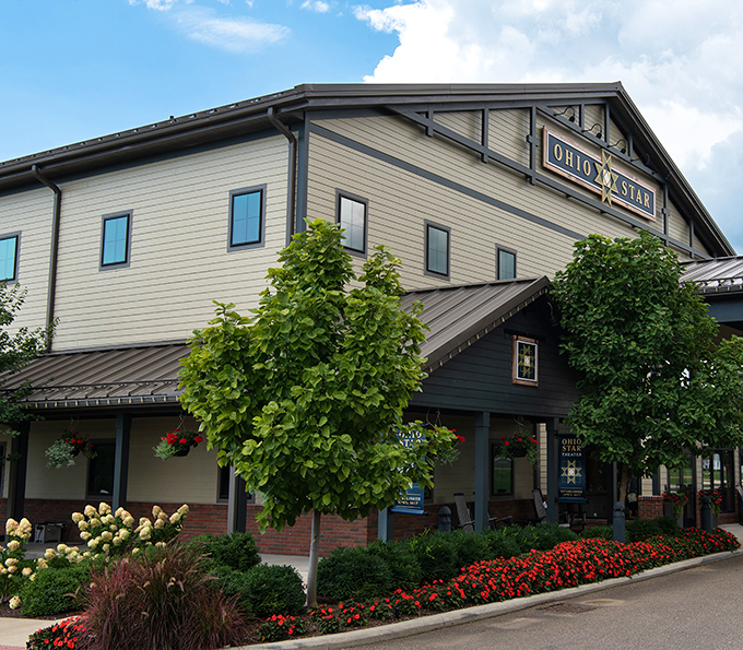 The Ohio Star Theater welcomes visitors with meticulous landscaping and modern amenities, proving that entertainment in Amish Country extends well beyond watching butter being churned.