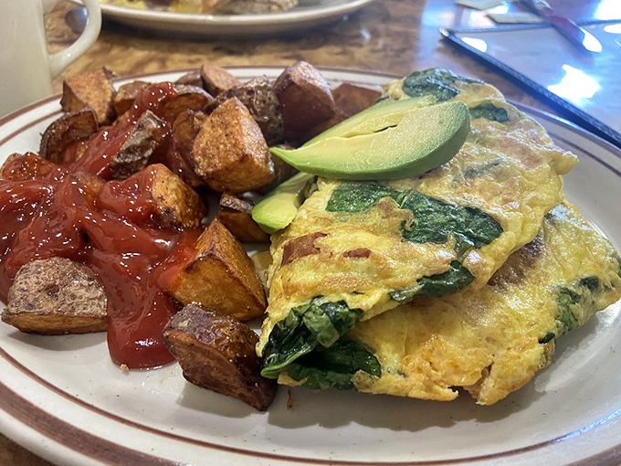 This isn't just an omelet &ndash; it's a masterclass in egg architecture, filled with spinach and paired with potatoes that achieved crispy perfection.