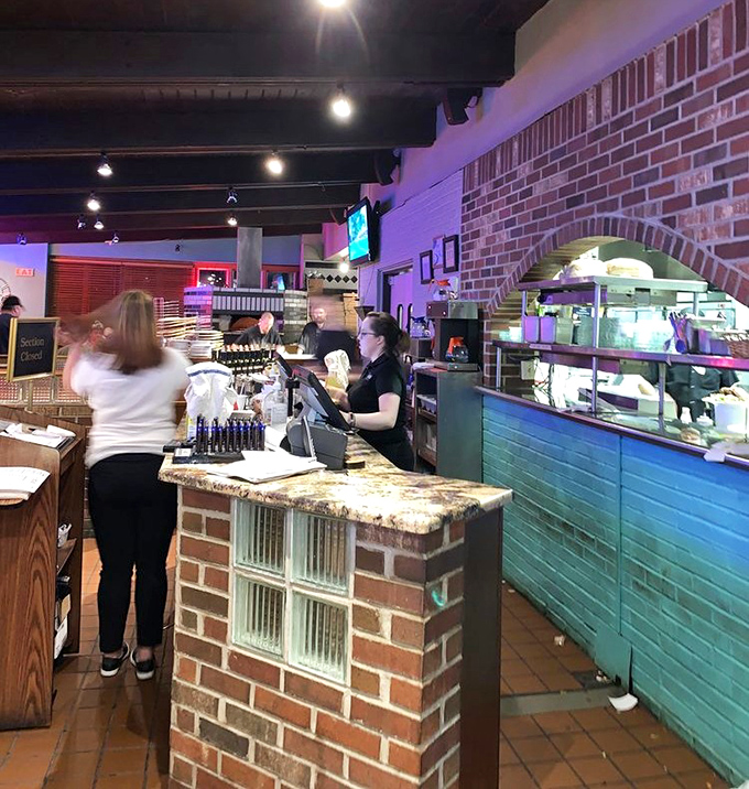 The command center where pizza dreams become delicious reality, complete with that essential brick oven backdrop that means business.