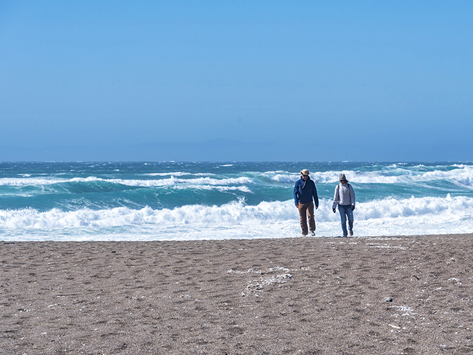 Two figures stroll along North Beach, having the kind of conversation that doesn't involve property taxes or traffic complaints.
