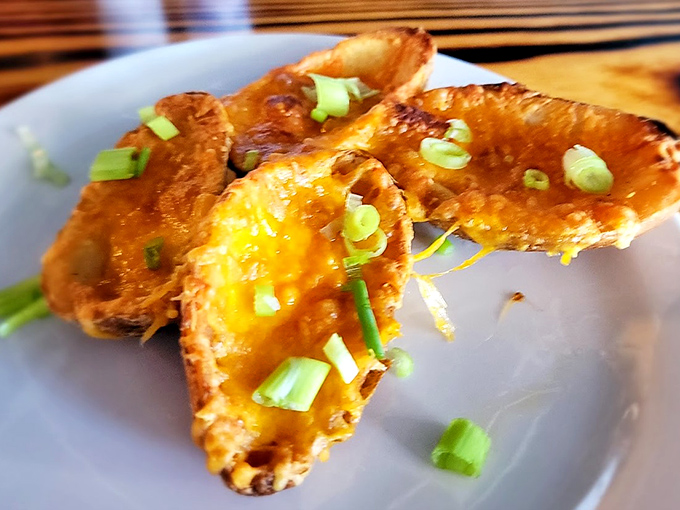 Potato skins that elevate the humble spud to art form. Crispy, cheesy, and topped with green onions – bar food that graduated with honors.
