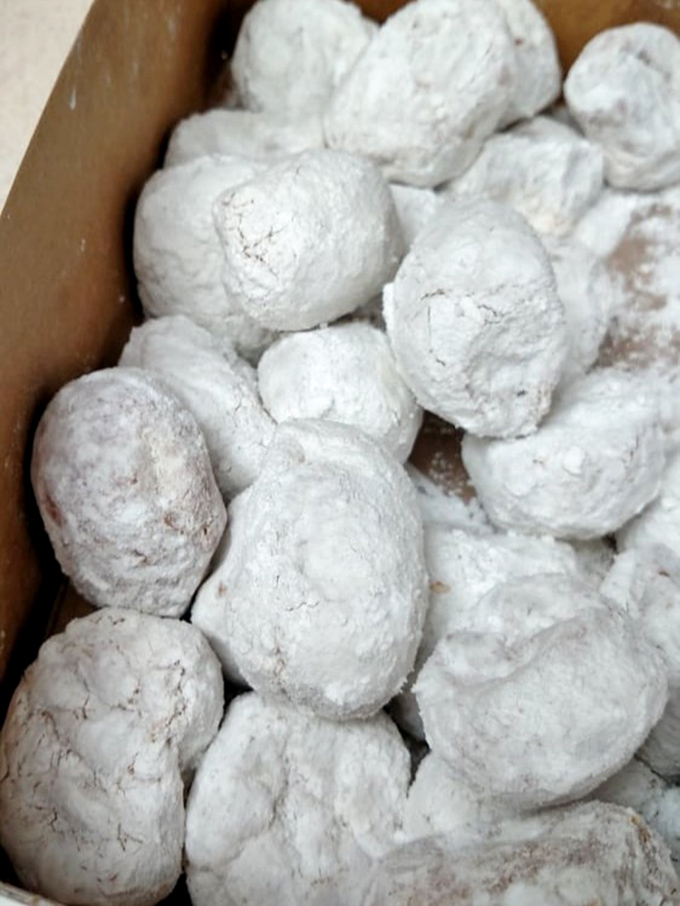 Powdered sugar donuts that require strategic eating techniques. One careless bite and you'll look like you lost a fight with a snowman.