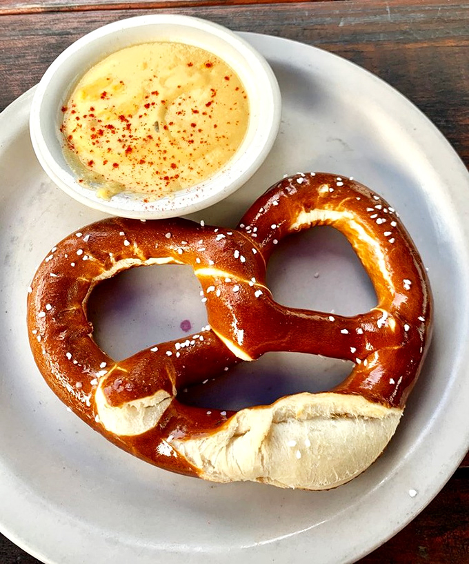 The pretzel that launched a thousand sighs. Mahogany-brown, salt-flecked perfection with beer cheese that demands to be dunked into repeatedly.