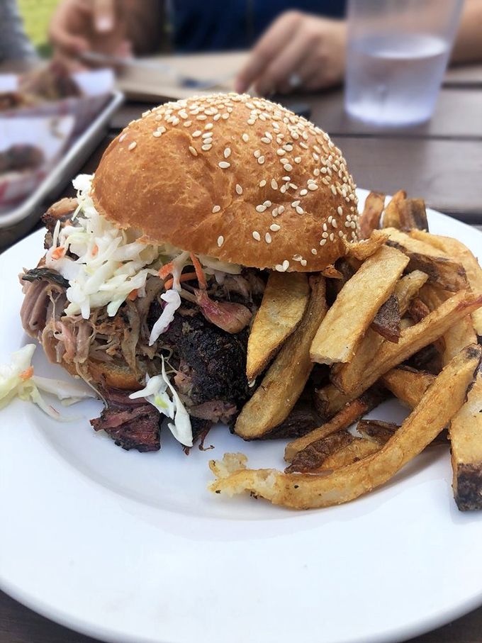 A sandwich that requires both hands and a strategy. This pulled pork masterpiece with slaw is architecture you can eat.