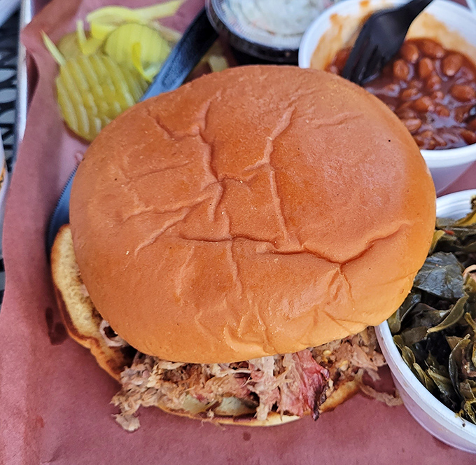 Pulled pork sandwich stacked high enough to require architectural engineering and maximum mouth expansion capacity.