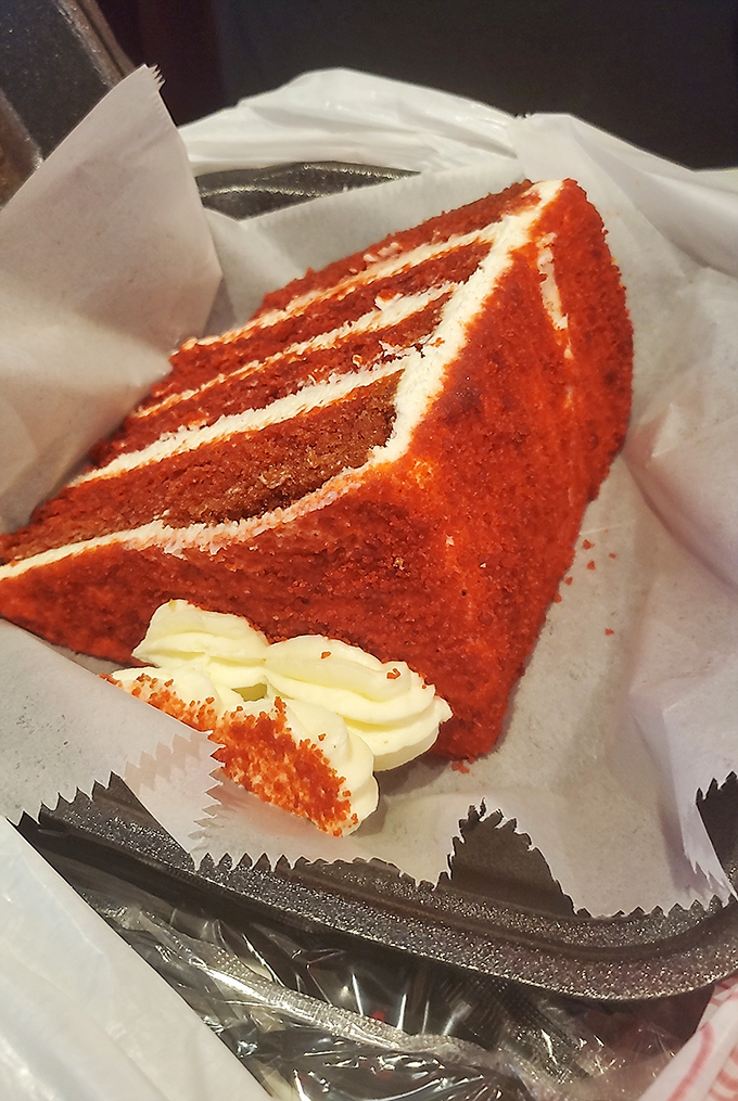 Red velvet cake so vibrant it could stop traffic, with cream cheese frosting applied with the kind of generosity we should all aspire to in life.
