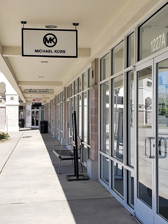 The outdoor walkway showcases premium brands like Michael Kors and Brooks Brothers, where your credit card can experience luxury without the usual panic attack.