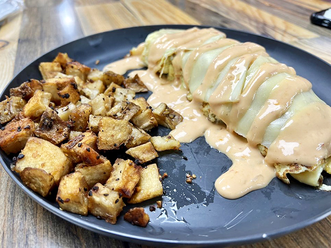 An omelette smothered in cheese sauce with perfectly seasoned potatoes on the side&mdash;breakfast's way of saying "I love you."