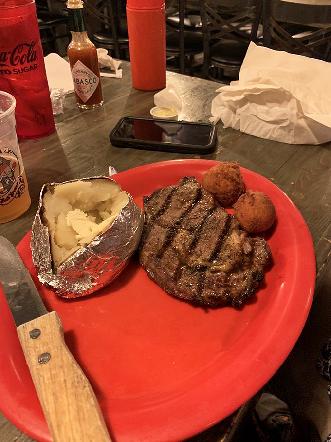 A steak that's seen just enough grill time to develop character without losing its soul. That baked potato in foil looks like it's wearing a tiny space suit.