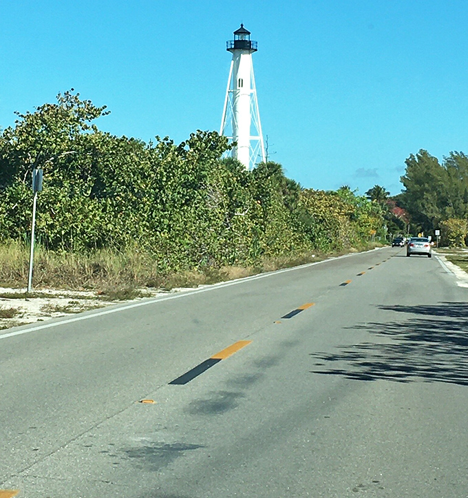Playing peekaboo through the greenery, the lighthouse stands as a white exclamation point against the perfect blue Florida sky.