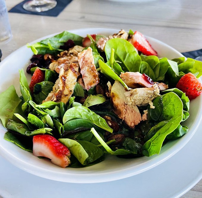 A salad that doesn't apologize for being healthy, brightened with strawberries and protein that makes you forget you're eating something virtuous.