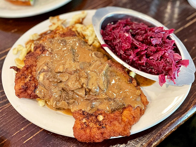 Schnitzel Champignon: where crispy breaded pork meets mushroom gravy and tangy red cabbage in a harmony that would make Mozart weep with joy.