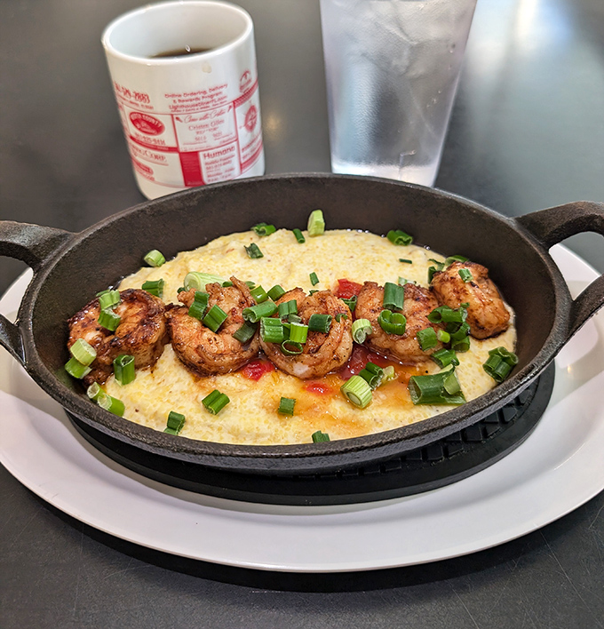 Shrimp and grits served sizzling hot in cast iron &ndash; Southern comfort food elevated to pure art form.