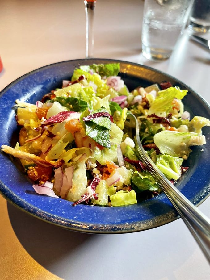 Even the side salad gets star treatment here—a vibrant bowl of crisp greens, colorful vegetables, and thoughtful dressing that's anything but an afterthought.