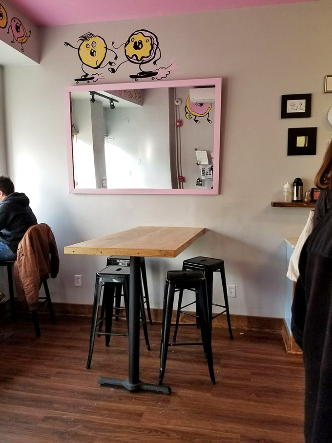 Whimsical donut characters skateboarding above the seating area, as if celebrating their escape from the display case.