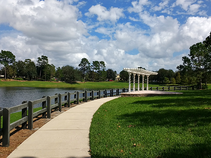 This serene park pathway leads to a gazebo that practically begs for wedding photos or quiet contemplation. Nature and architecture in perfect harmony.