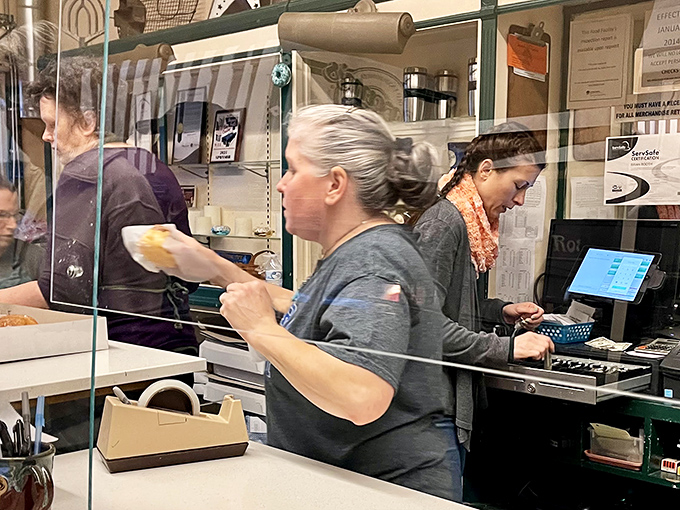Behind the counter, the real magic happens as staff members orchestrate the daily donut ballet with practiced precision.