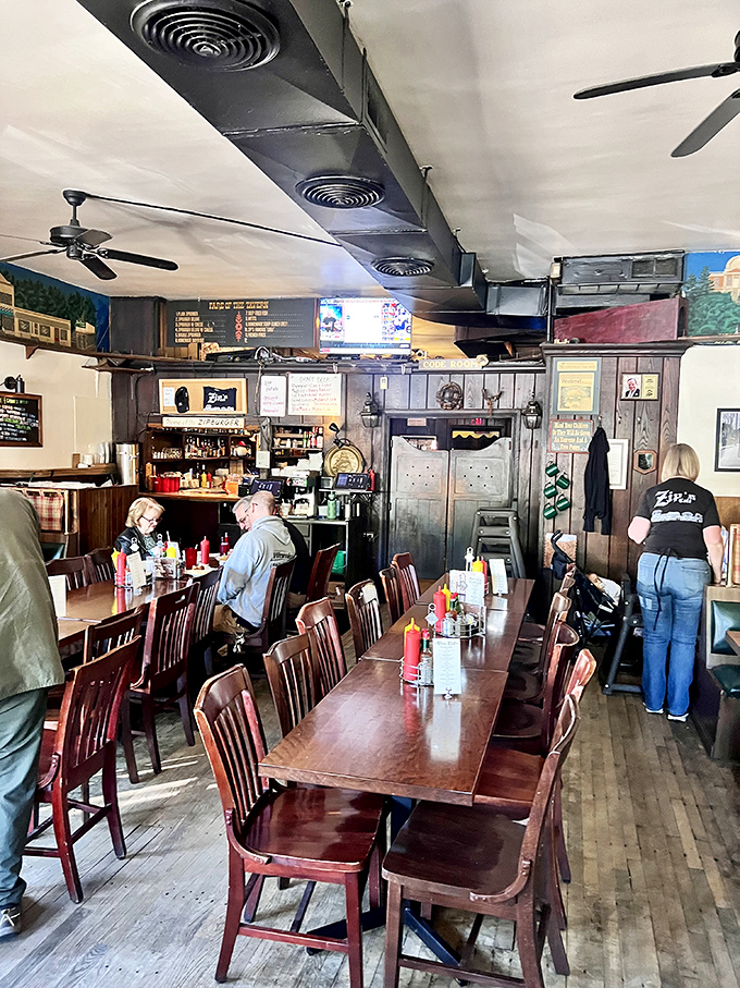 The heart of Zip's&mdash;where wooden tables gather beneath ceiling fans, creating the perfect backdrop for conversations that flow as easily as the local beer.