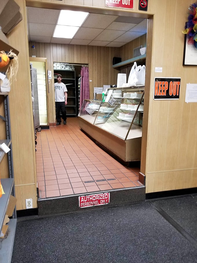 A glimpse behind the curtain reveals the no-nonsense bakery operation. That "KEEP OUT" sign means business &ndash; the cake business.