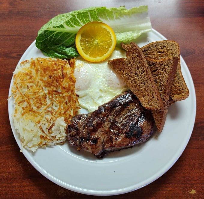 A breakfast classic ready for its close-up&mdash;perfectly grilled steak, sunny-side-up eggs, crispy hash browns, and rye toast with a slice of lemon for that unexpected twist.