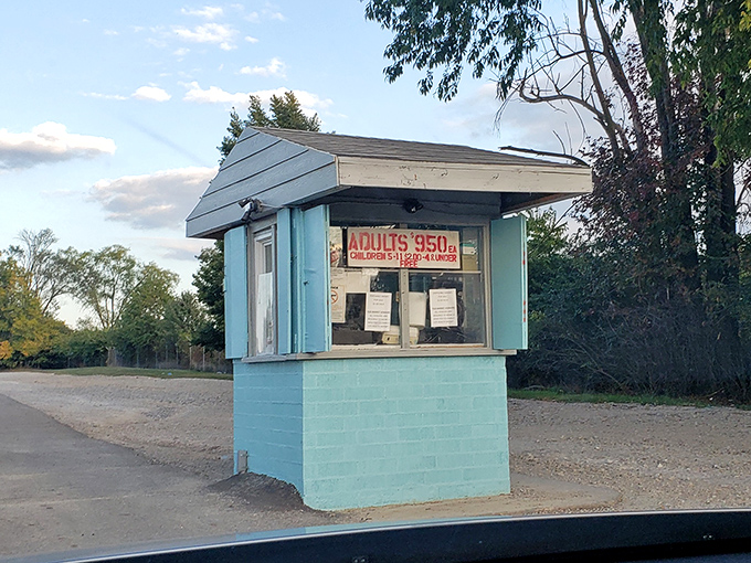 The charming blue ticket booth, last gatekeeper of a disappearing American tradition, promising affordable movie magic.