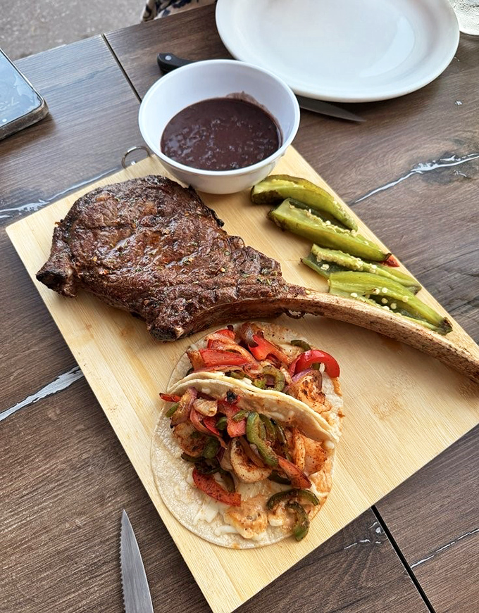 A tomahawk steak and taco situation that makes you wonder if you've died and gone to protein heaven. Carnivore poetry on a wooden board.