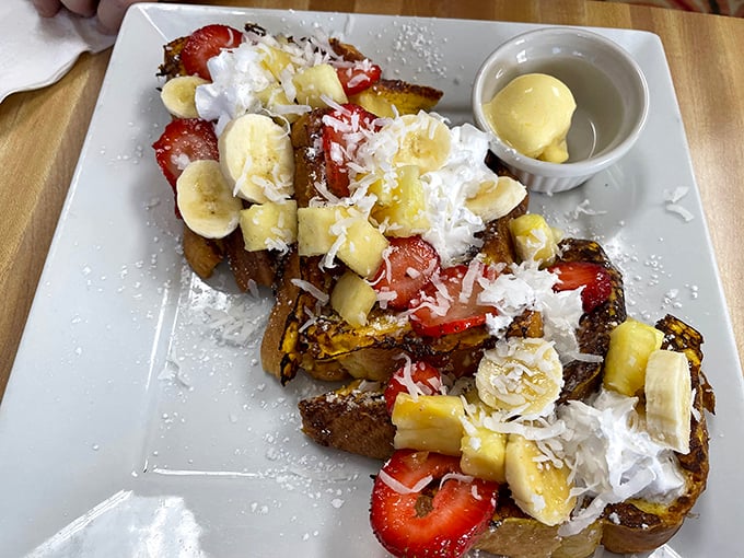 French toast gets the royal treatment with fresh strawberries, bananas, and whipped cream creating breakfast dessert perfection.