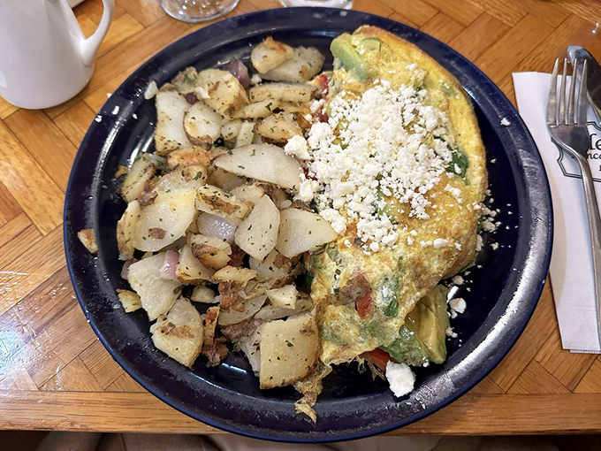A veggie omelet that doesn't feel like punishment – perfectly cooked eggs embracing fresh vegetables and crowned with feta that adds just the right tang.