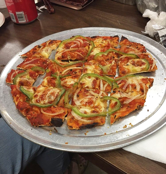 Green peppers and onions arranged like modern art on a canvas of cheese and sauce&mdash;proof that vegetables can be both virtuous and delicious.