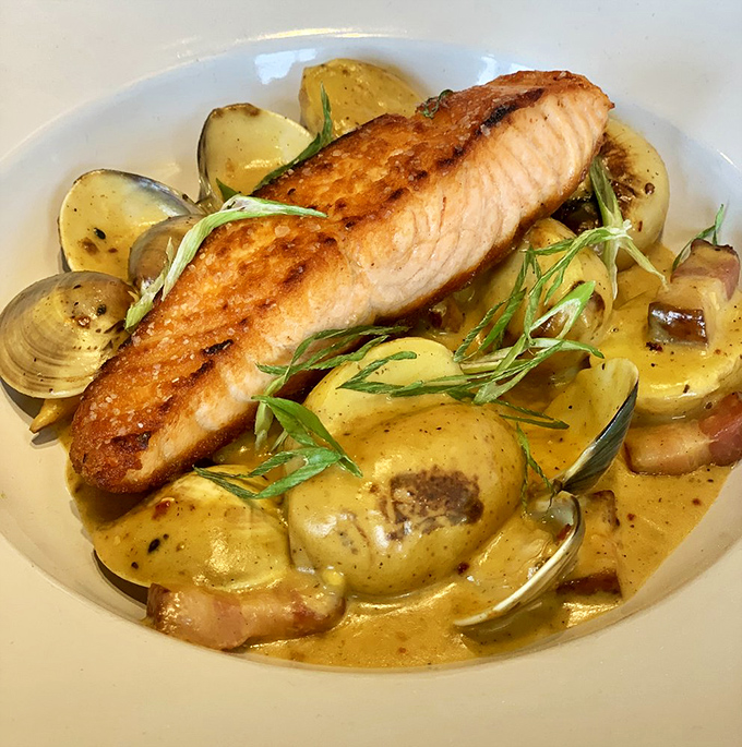 Salmon that looks like it jumped from stream to plate, resting on potatoes and surrounded by a sauce that demands to be sopped up.