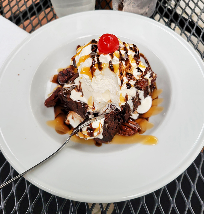 Some desserts whisper. This brownie sundae announces itself with trumpets, caramel rivers, and chocolate islands of pure joy.
