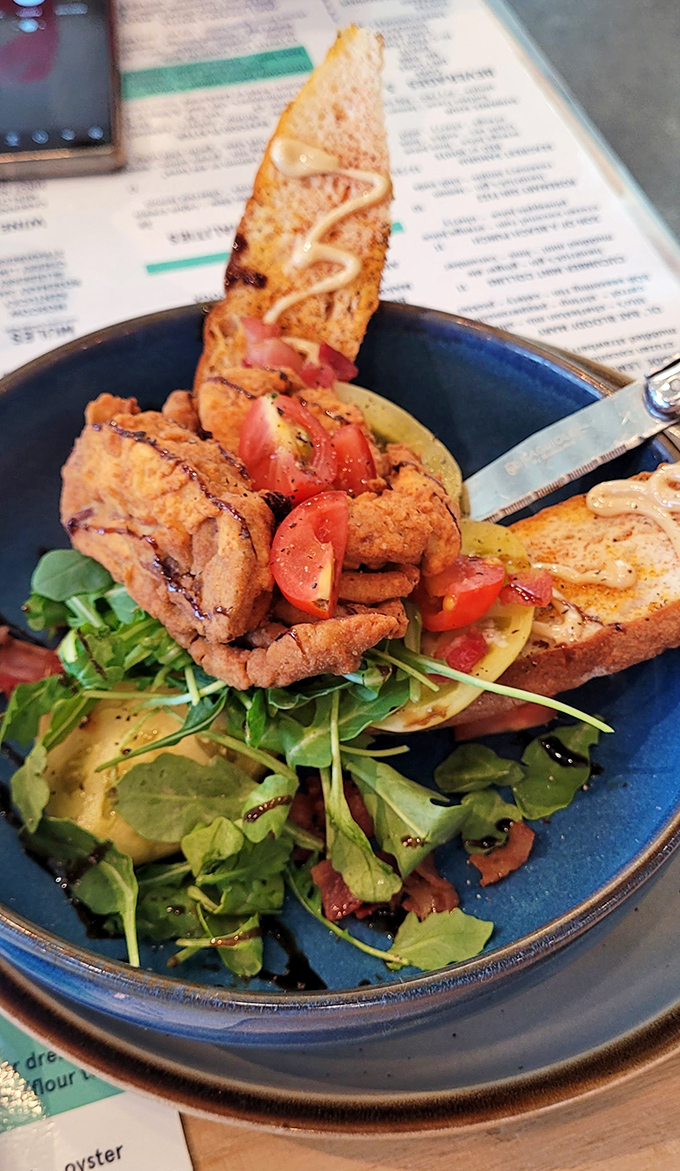 This isn't just fried seafood&mdash;it's an artistic statement. Crispy exterior giving way to tender fish, all resting on a bed of peppery arugula.