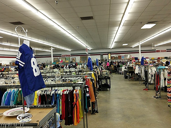 A football jersey stands sentinel over a sea of color-coded clothing. In thrift store geography, organization is the difference between treasure and chaos.