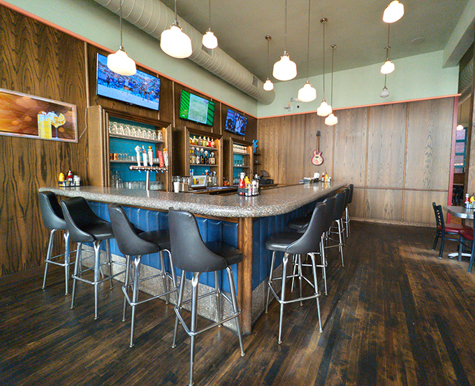 The bar area offers front-row seats to culinary theater. Wood-paneled walls have absorbed decades of laughter, creating the perfect acoustic environment for clinking glasses.