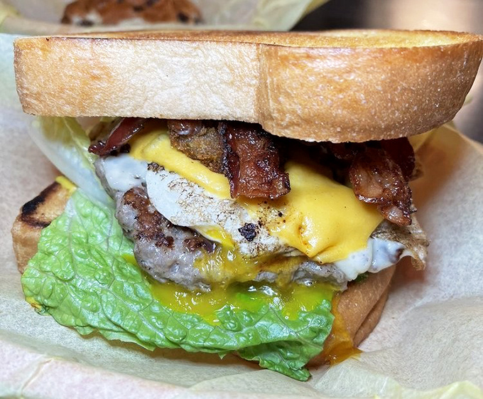 A burger that requires both hands and possibly a signed liability waiver. That egg yolk is about to make a glorious mess worth every napkin.