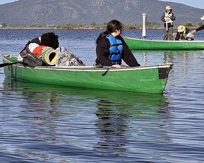 Green canoes loaded with adventure essentials&mdash;proof that the best journeys often start with simple vessels and hopeful hearts.