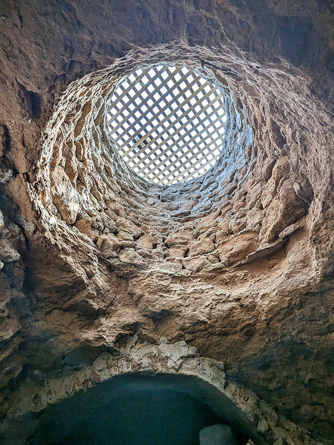 Looking up through a hand-carved light well reveals engineering brilliance. This natural skylight bathes the underground space in dappled sunshine.