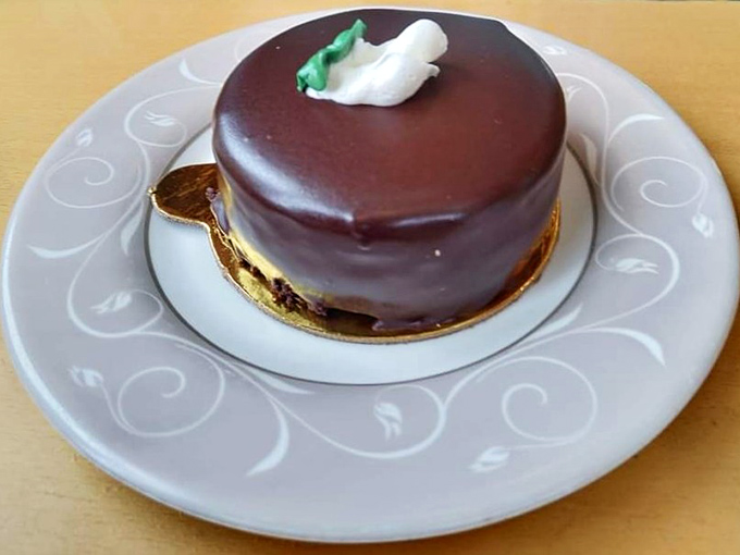 A chocolate mousse cake so perfectly formed it seems to defy physics&mdash;the glossy ganache surface reflecting your expression of pure anticipation.