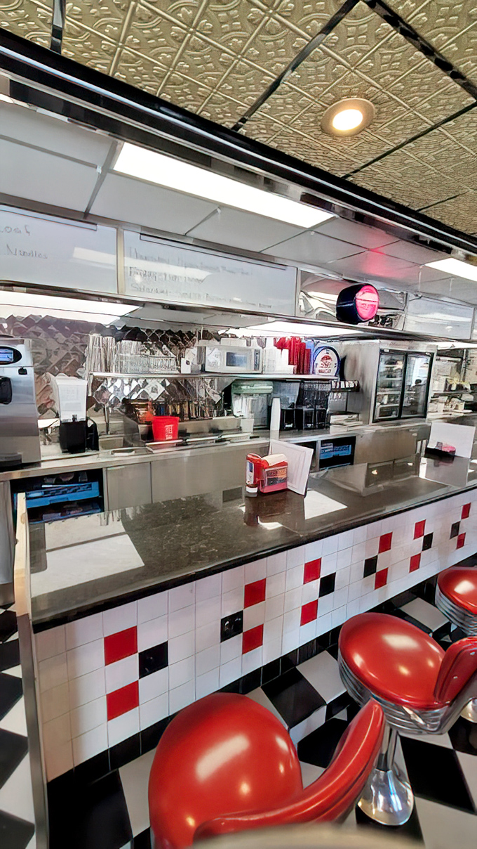 The counter where magic happens&mdash;red stools await hungry patrons while stainless steel gleams with promises of comfort food bliss.