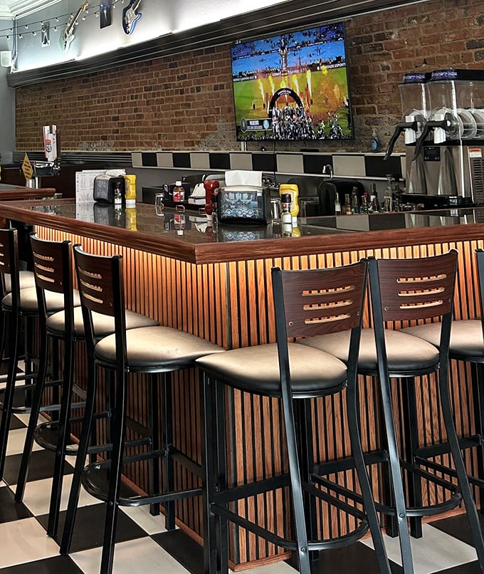 The bar where strangers become friends, backed by exposed brick and wood paneling that whispers, "Stay awhile, the stories are just getting good."