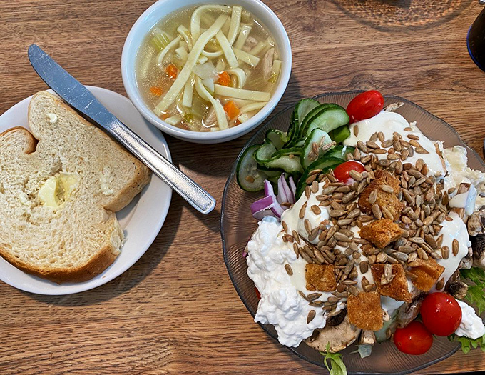 A perfect trifecta: homemade bread with a pat of butter, chicken noodle soup, and a cottage cheese salad that grandmothers everywhere would approve.