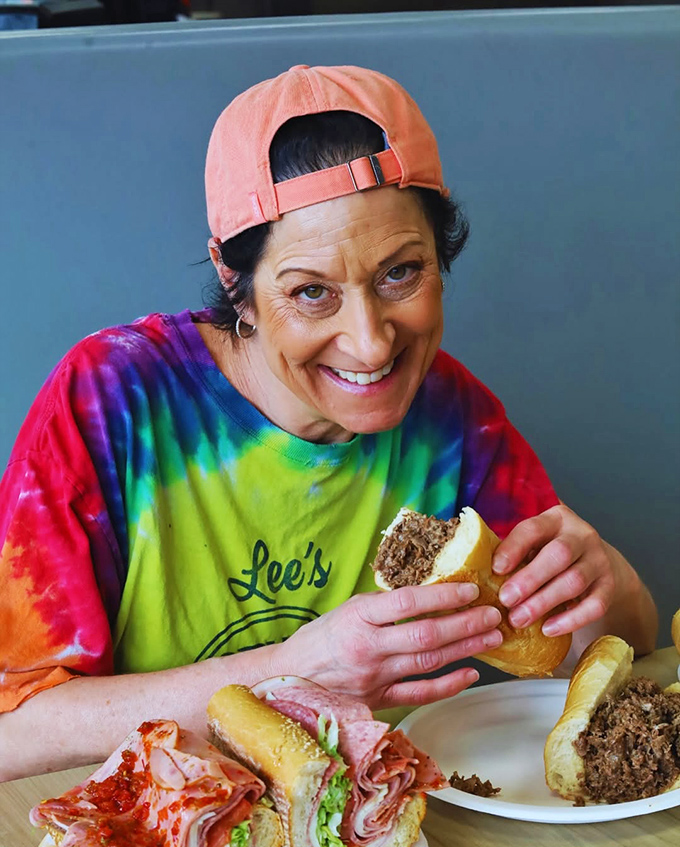 A loyal customer enjoying her Lee's experience. That smile says everything words can't about sandwich satisfaction.