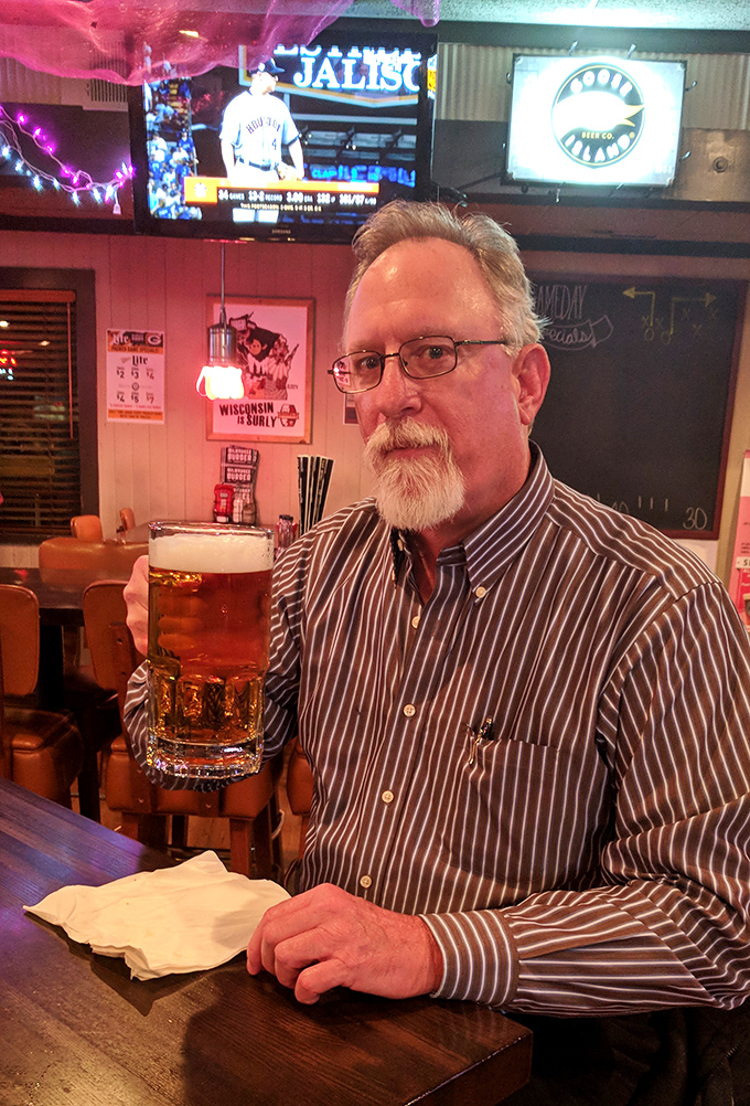 A patron savoring a perfectly poured beer, capturing that quintessential Wisconsin moment when thirst meets craftsmanship.