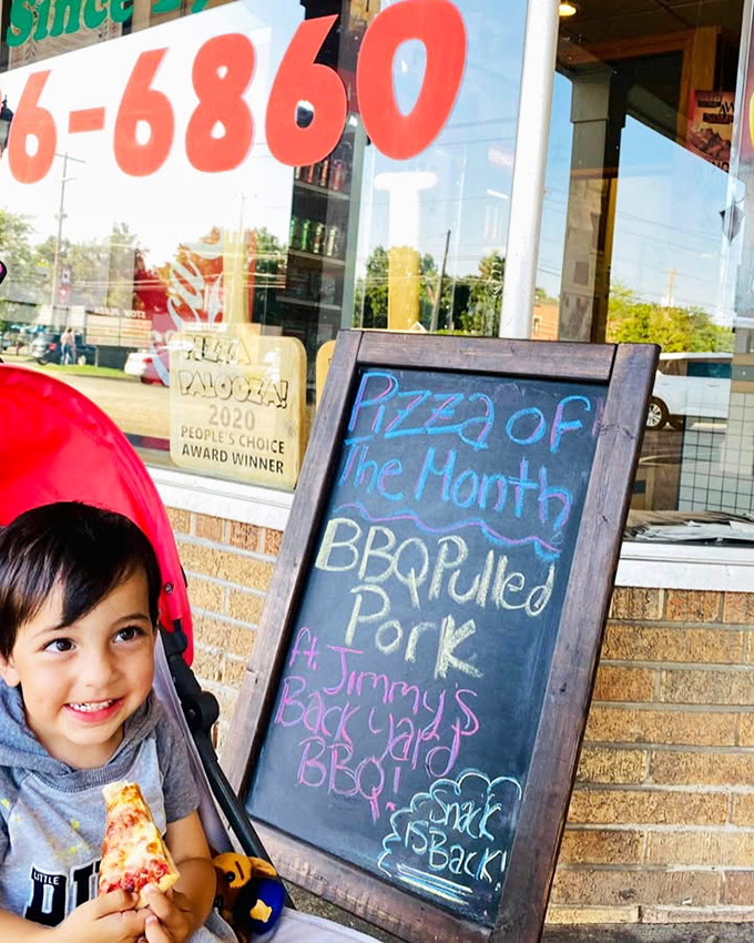 Nothing says "childhood joy" quite like a kid in a stroller experiencing their first slice of pizza enlightenment.